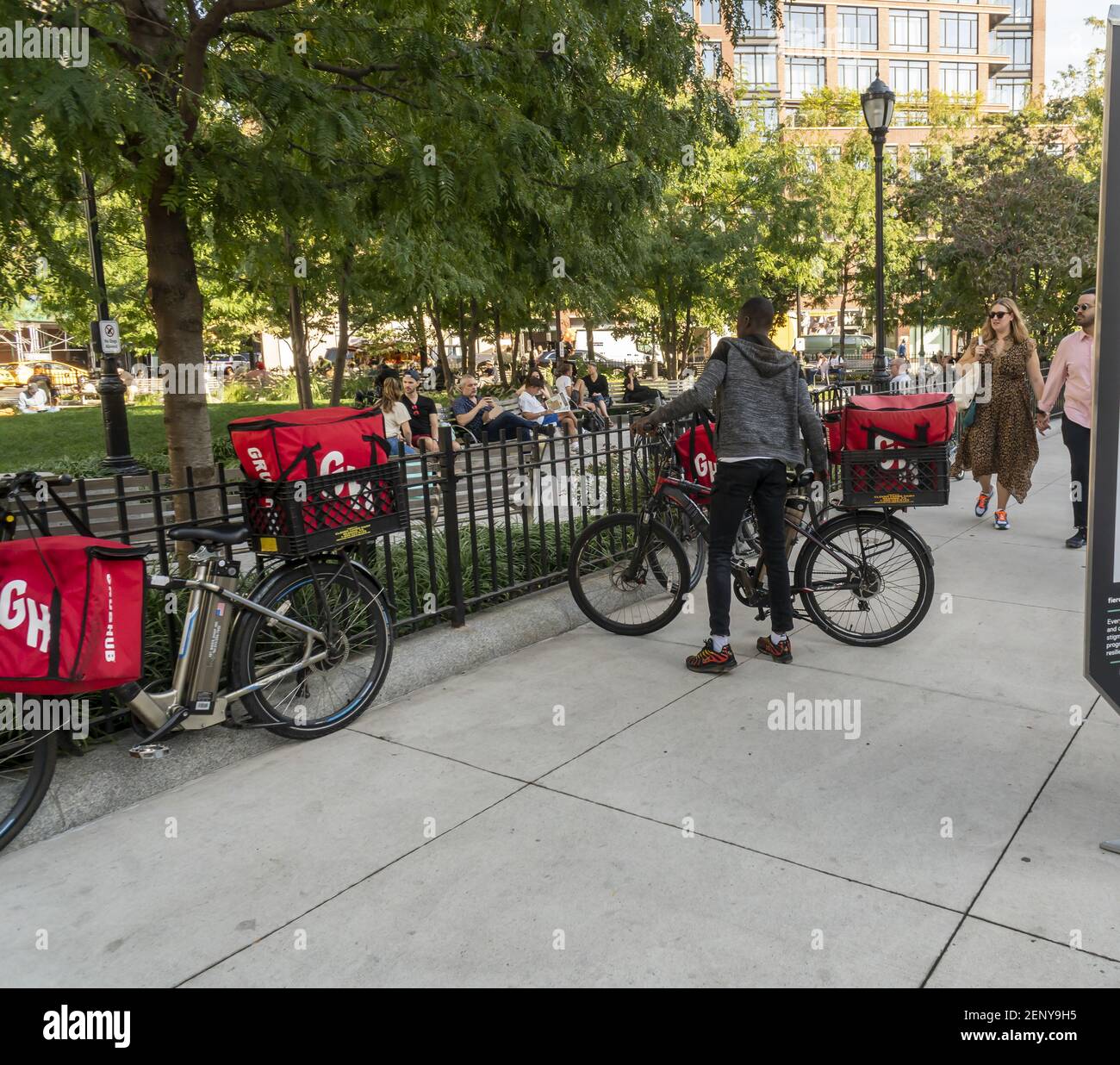 A GrubHub delivery worker parks his bike and joins other workers to ...