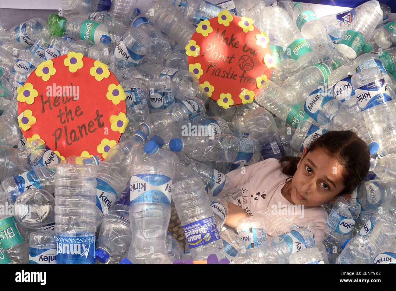 Young girl lay inside heap of plastic used bottles during International ...