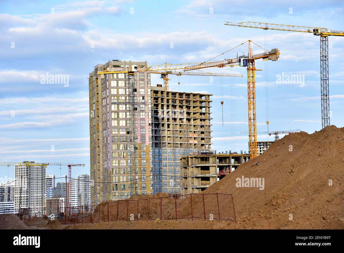 Tower crane in action at construction site on blue sky background ...
