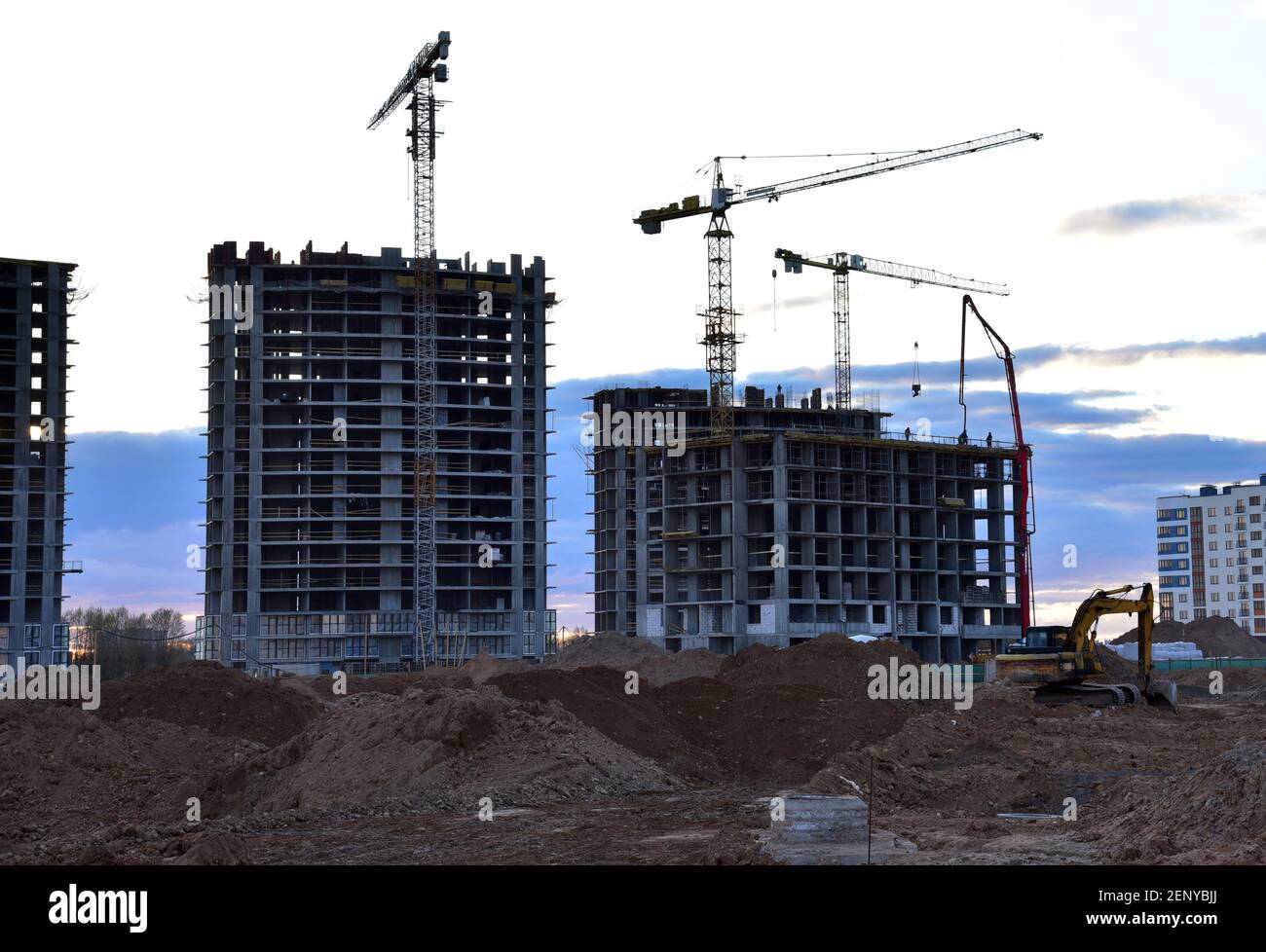 Tower crane in action at construction site on blue sky background ...