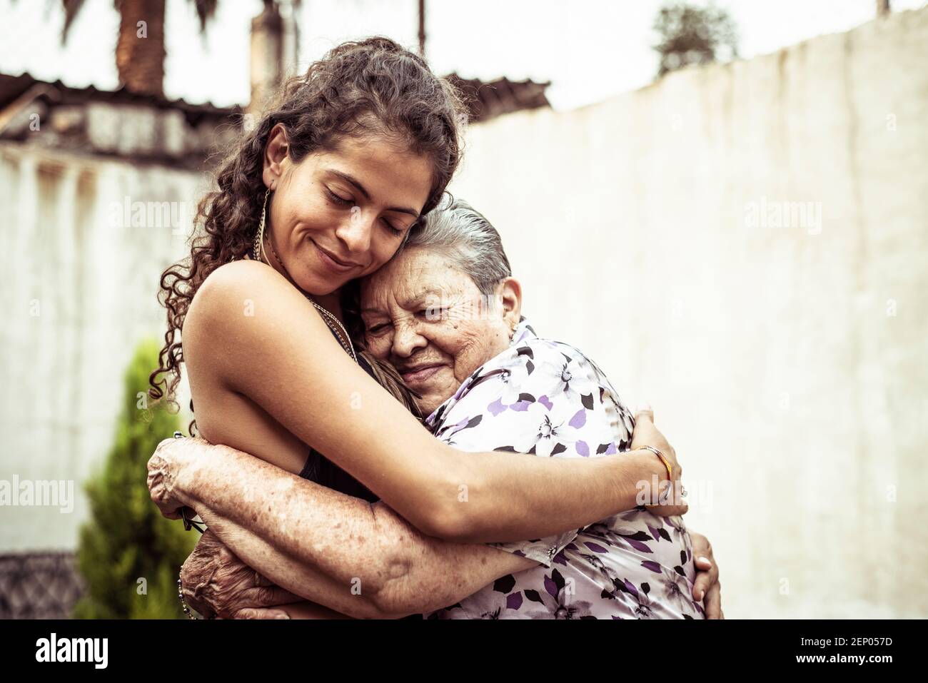 Mexican women smile in loving hug embrace on summer street Mecxico ...
