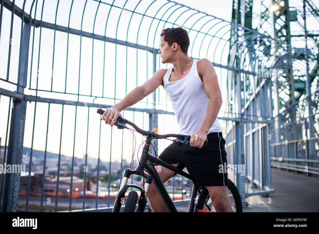 Young man running on bike path in urban city setting at sunset Stock ...