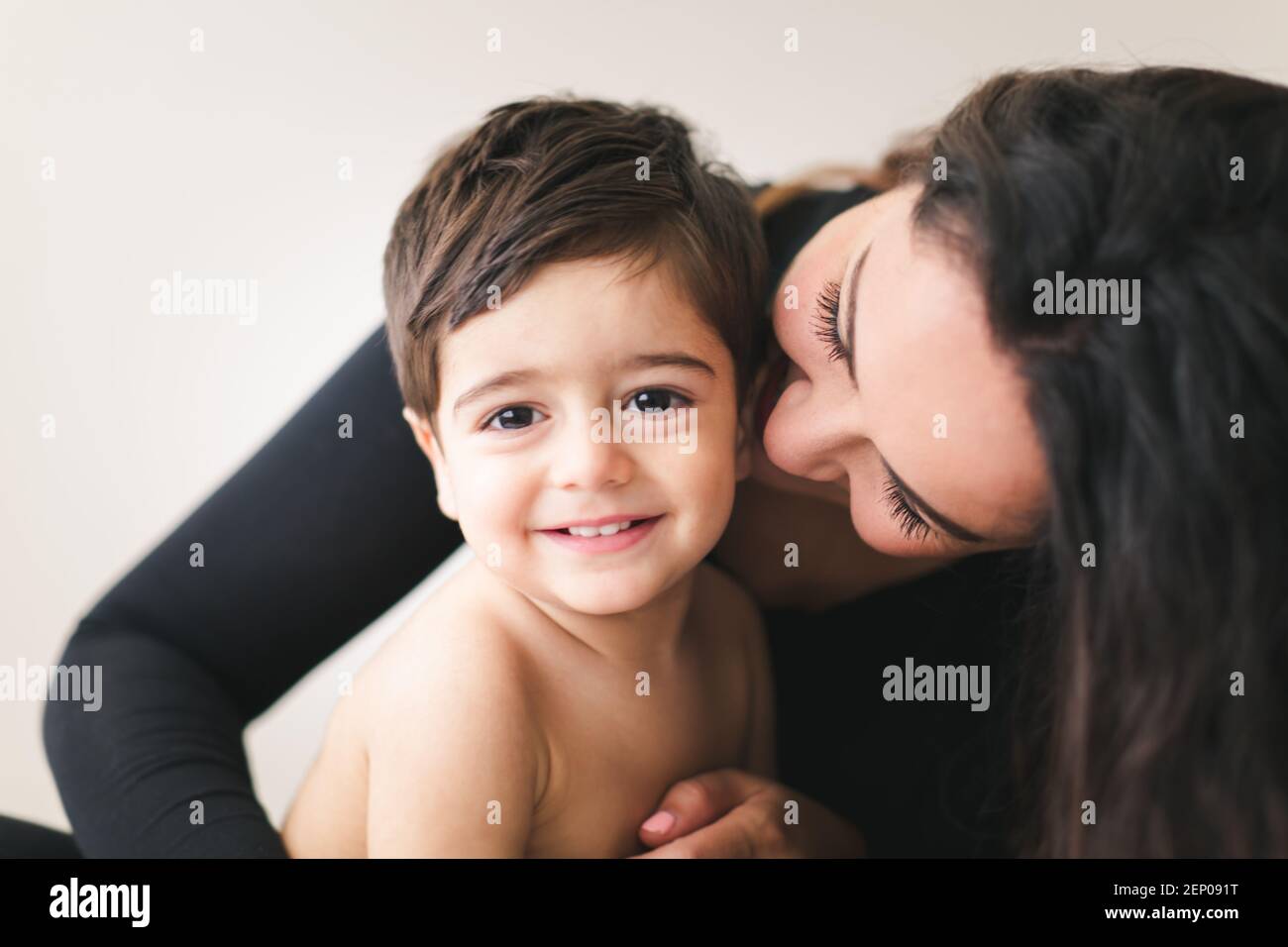 Mom whispering in son's year while he looks at the camera Stock Photo ...