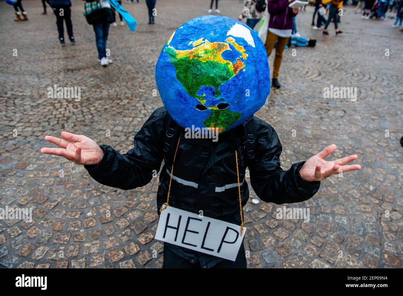 A man with an earth ball on his head makes gestures during the ...