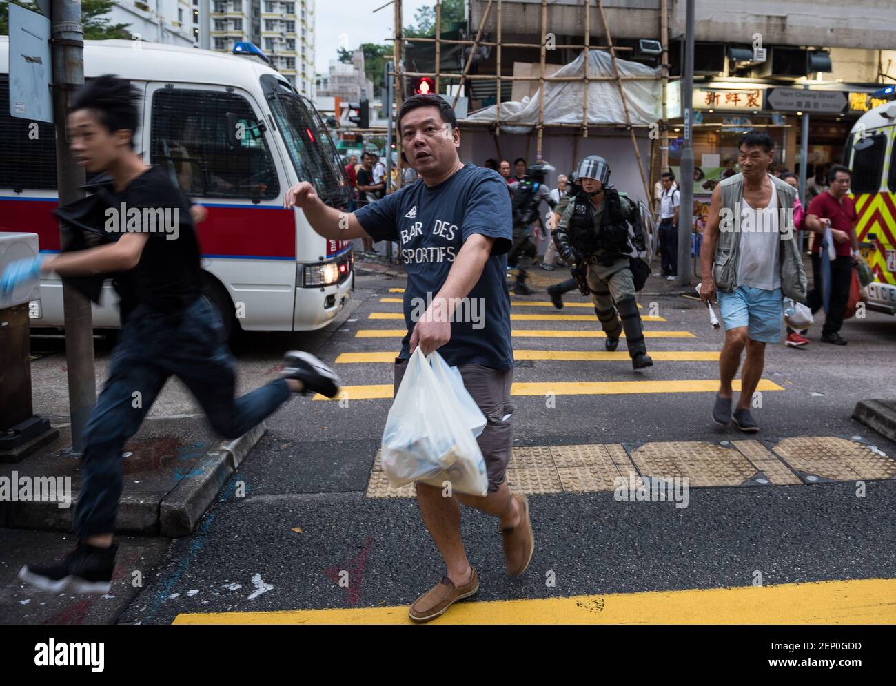 A protester sprints away from a riot police officer while local ...
