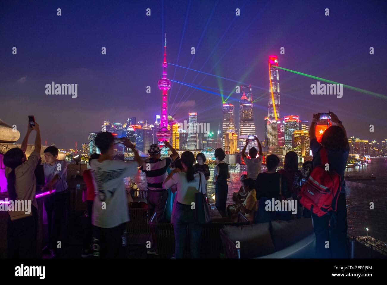 Tourists gather at the Bund to enjoy the light show performed with ...