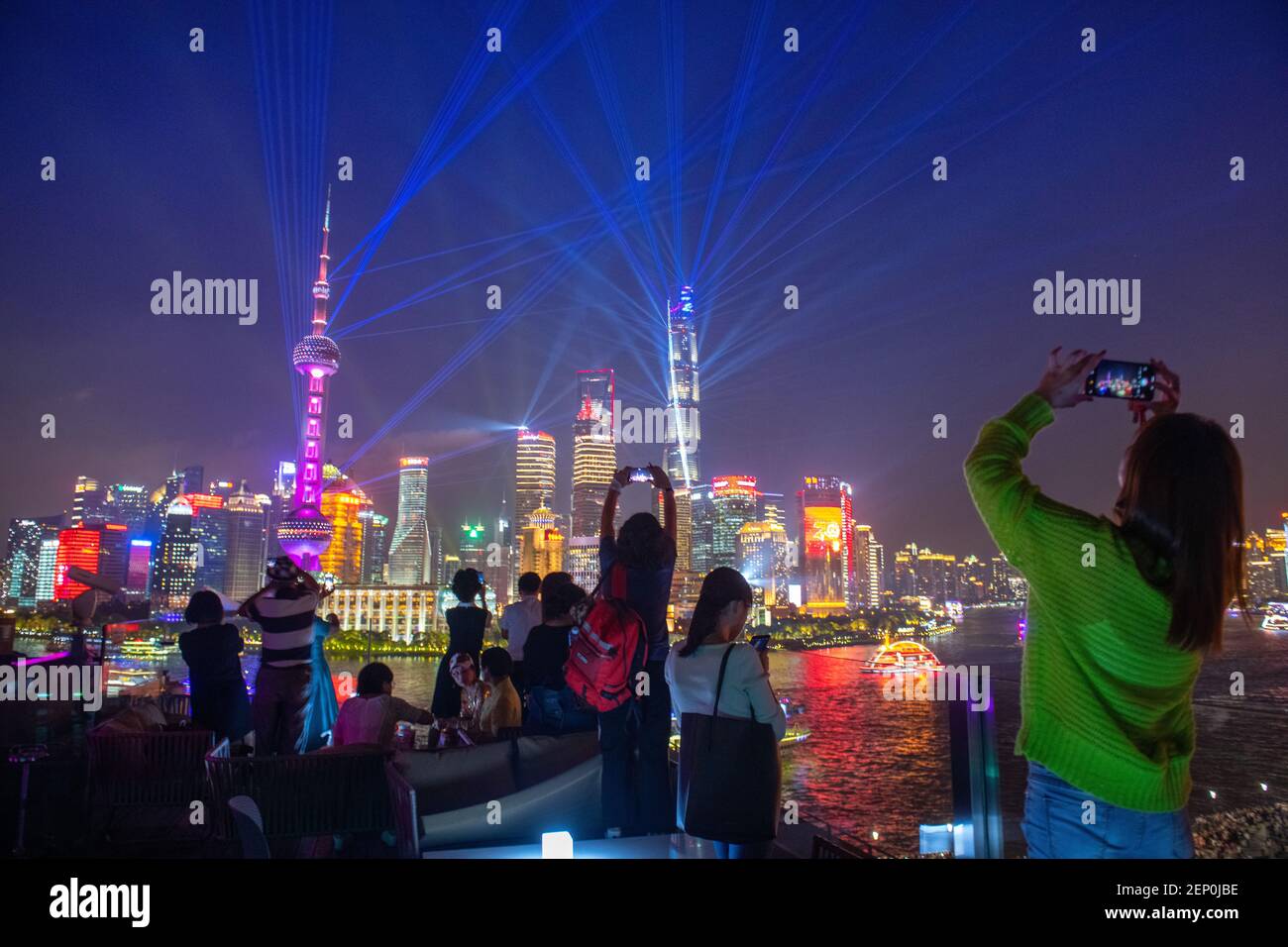 Tourists gather at the Bund to enjoy the light show performed with ...