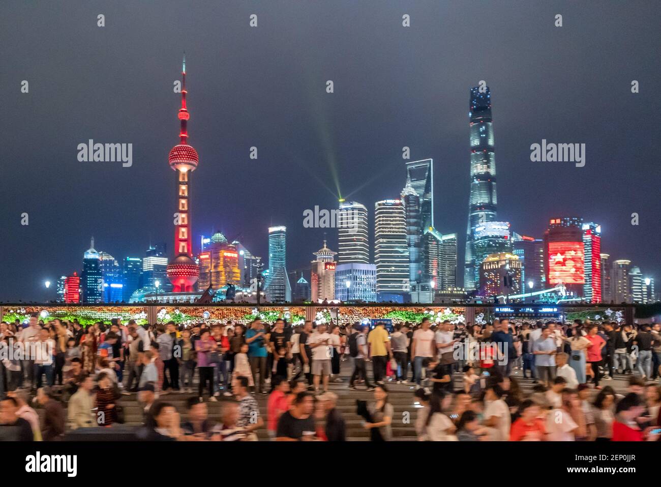 Tourists gather at the Bund to enjoy the light show performed with ...