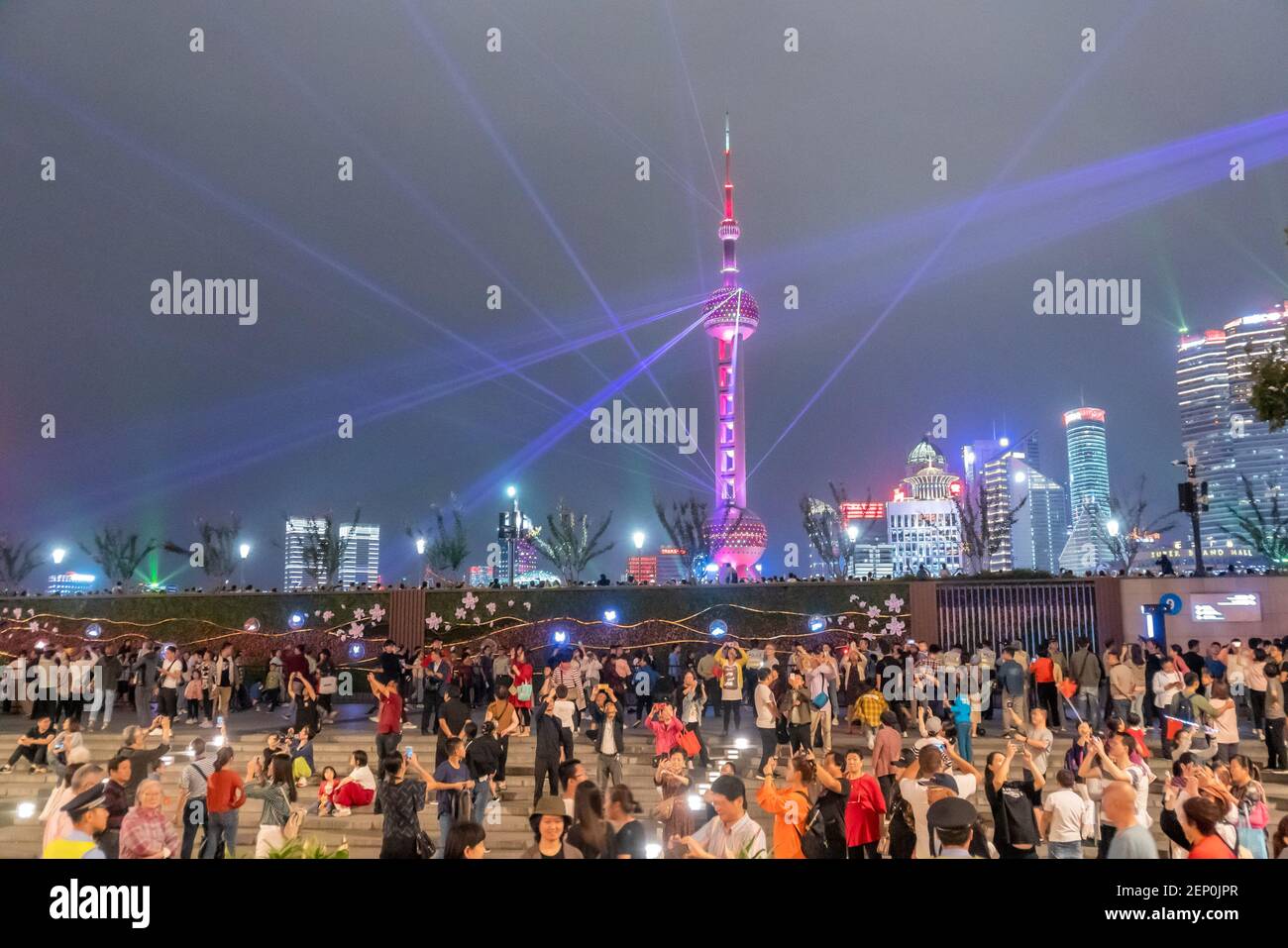 Tourists gather at the Bund to enjoy the light show performed with ...