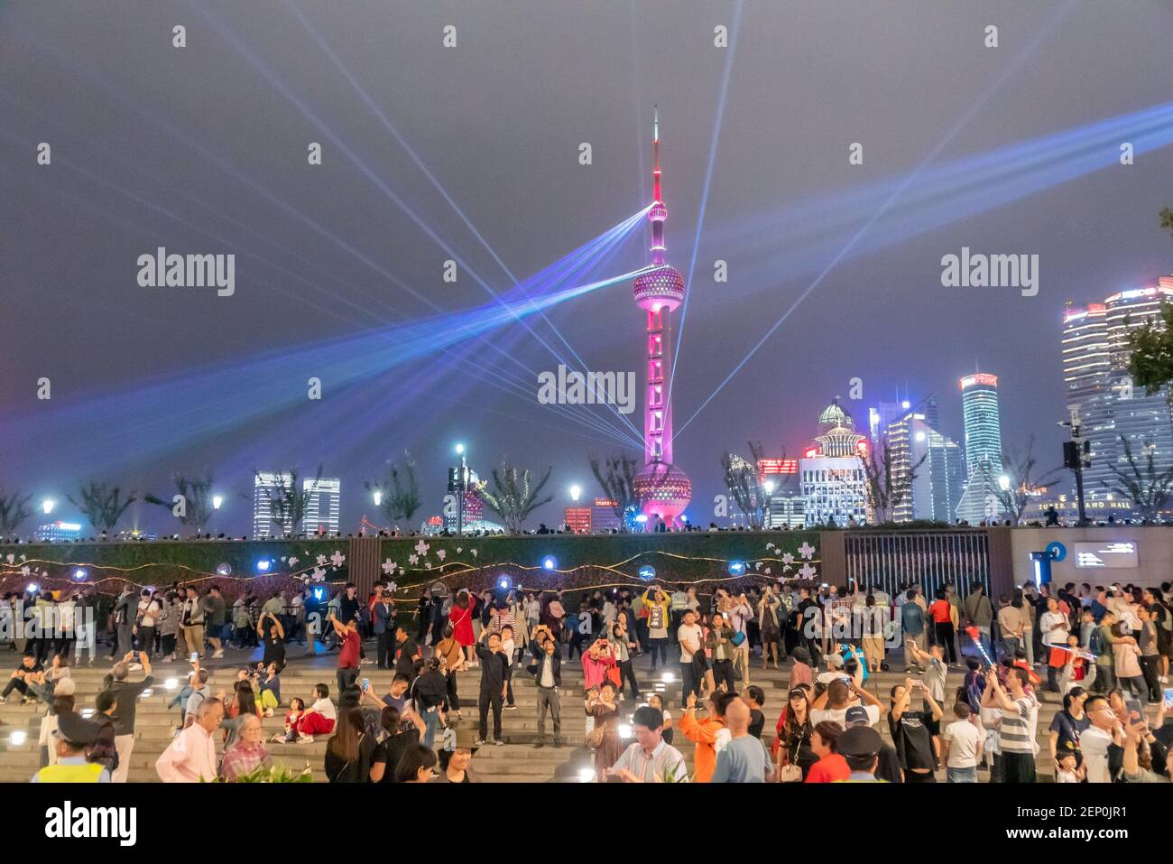 Tourists gather at the Bund to enjoy the light show performed with ...