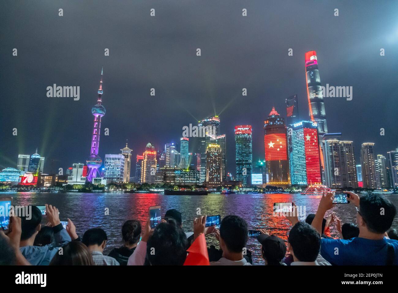 Tourists gather at the Bund to enjoy the light show performed with ...
