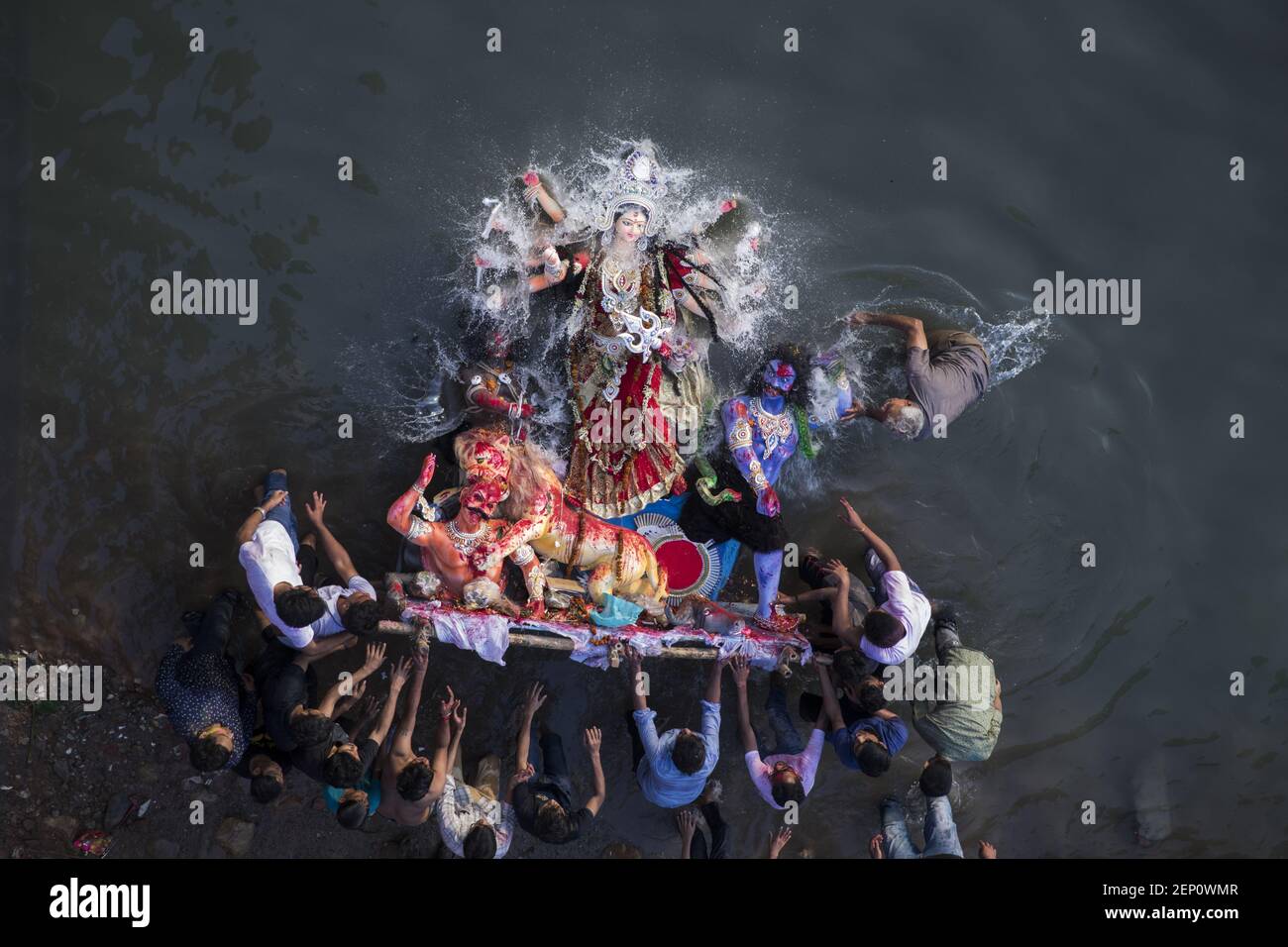 Hindu devotees immerse an idol of the Hindu goddess Durga in the ...