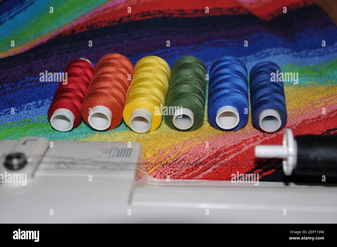 Sewing threads of the colors of the rainbow on the background of ...