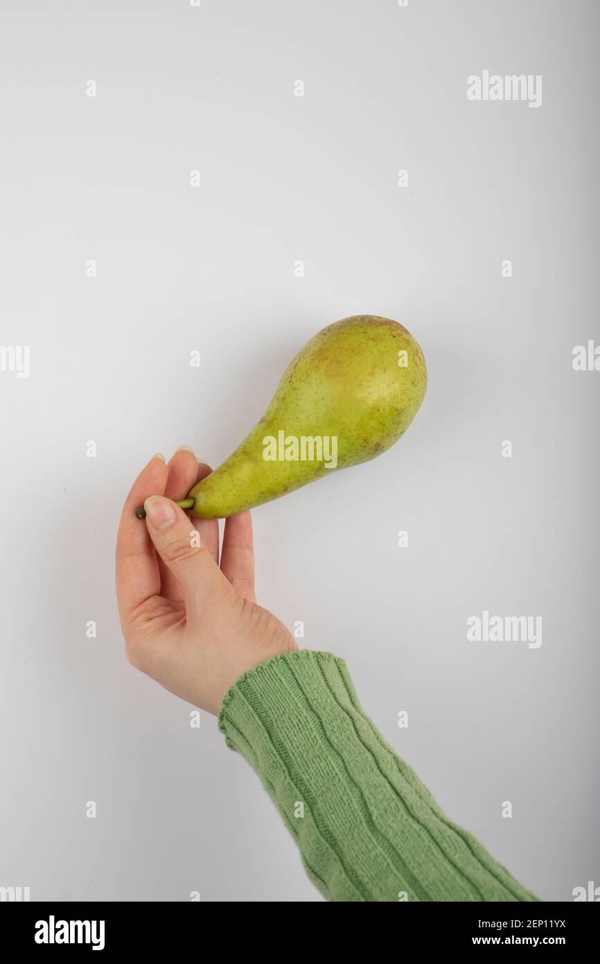 Female hand holding tip of green pear on white background Stock Photo ...