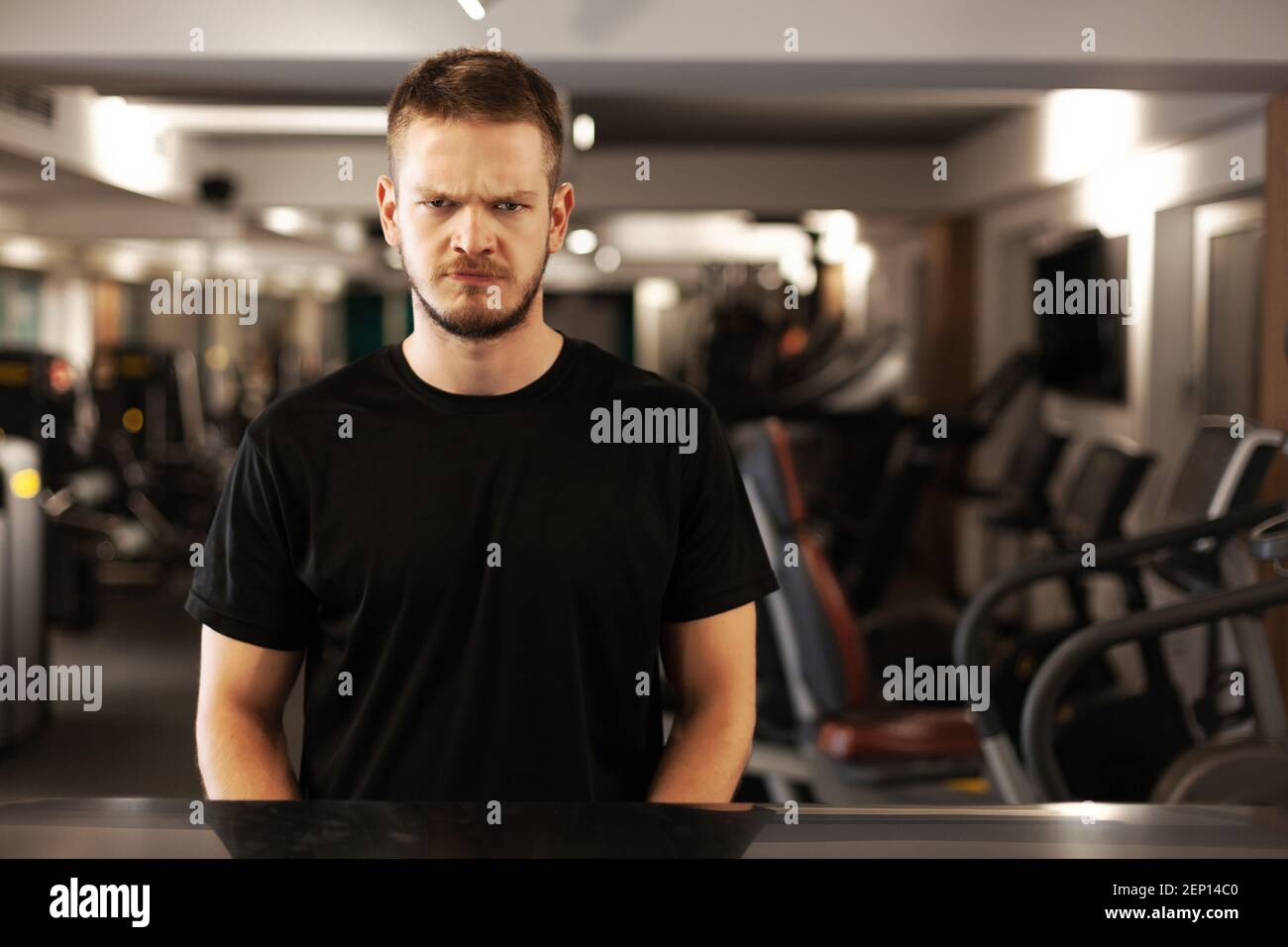 angry man standing and looking at camera in a generic out of focus ...