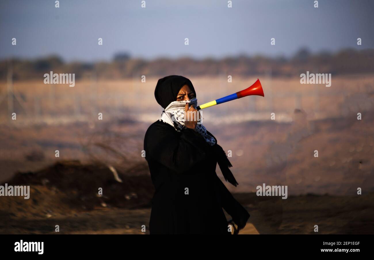 A Palestinian demonstrator uses a beep to disturb Israeli forces during ...