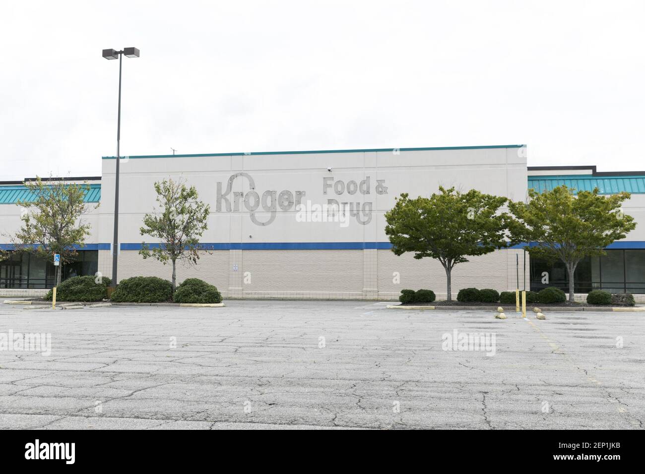 The outline of a logo sign outside of a closed Kroger retail grocery ...