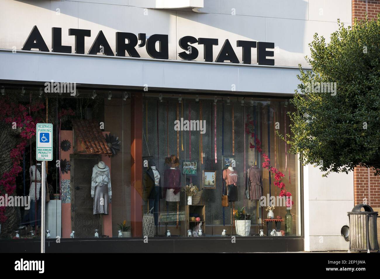 A logo sign outside of a Altar'd State retail store location in ...