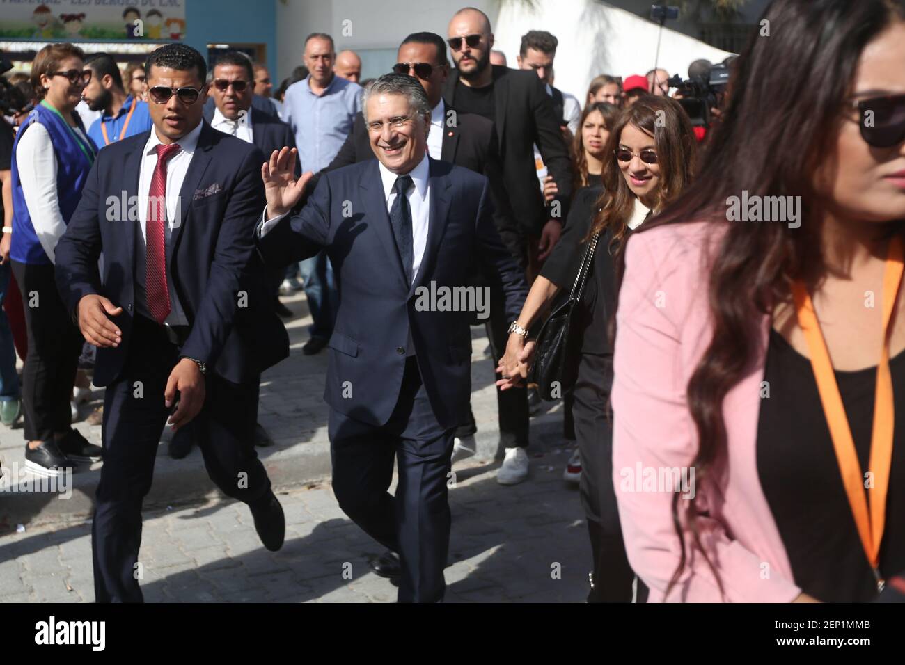 Nabil Karoui waves with his wife front the polling station during ...