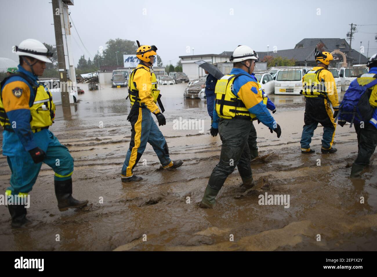 NAGANO, JAPAN - OCTOBER 14: Rescue personnel walks in the muddy road ...
