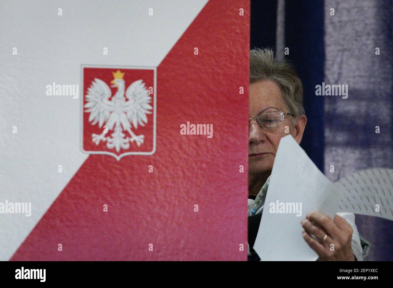 A woman is seen reading the list of voters at a voting station in ...