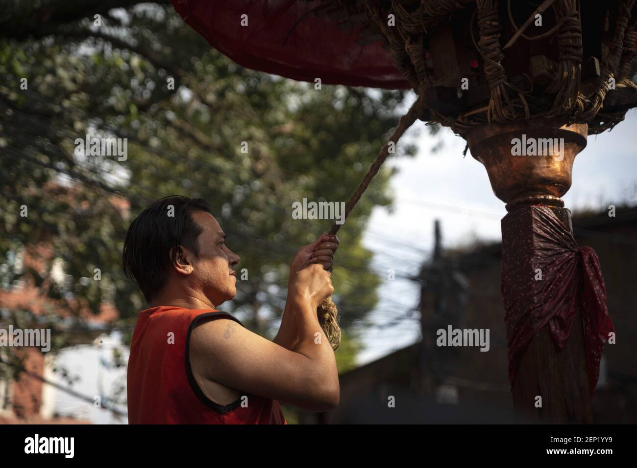 A devotee spins the top part of a chariot of Lord Narayan during the ...
