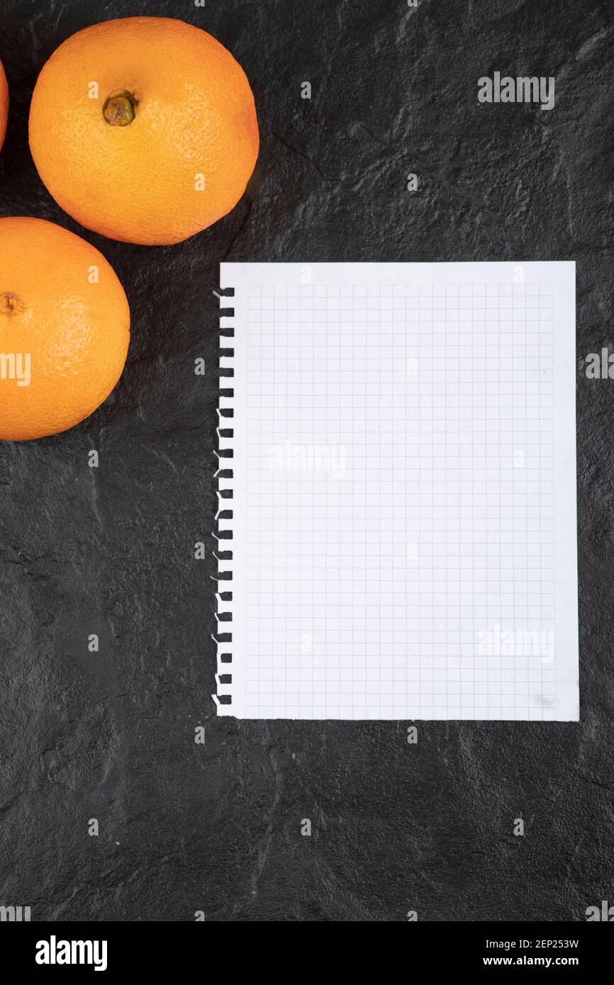Healthy orange fruits with an empty sheet of paper on black table Stock ...
