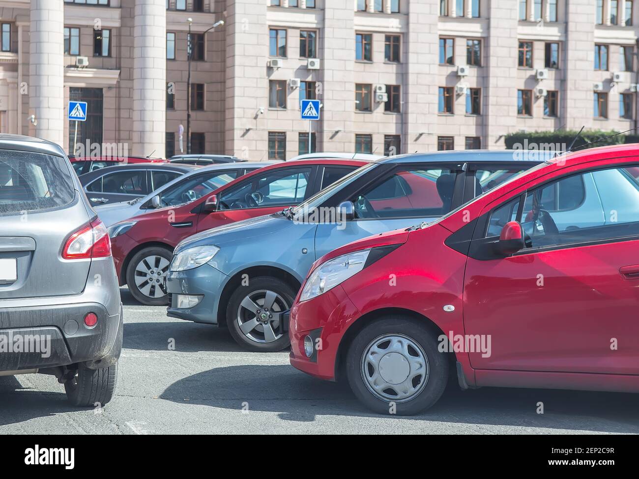 Cars in parking place near the entrance into classic style building ...