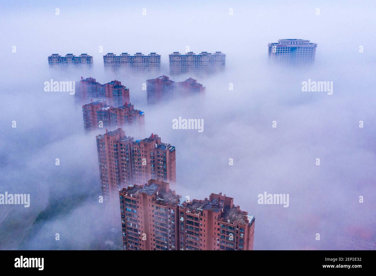 An aerial view of buildings in the downtown area standing in fog in ...