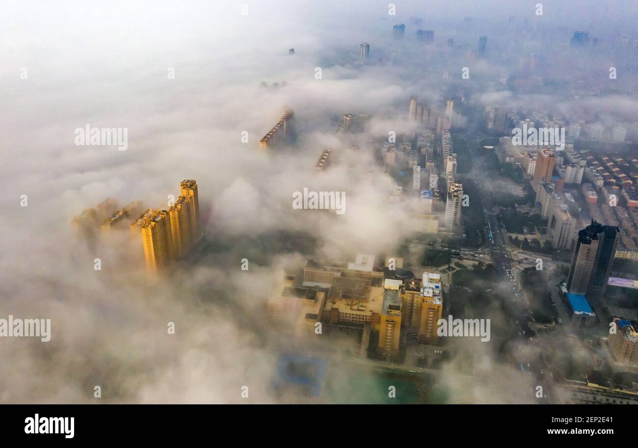 An aerial view of buildings in the downtown area standing in fog in ...
