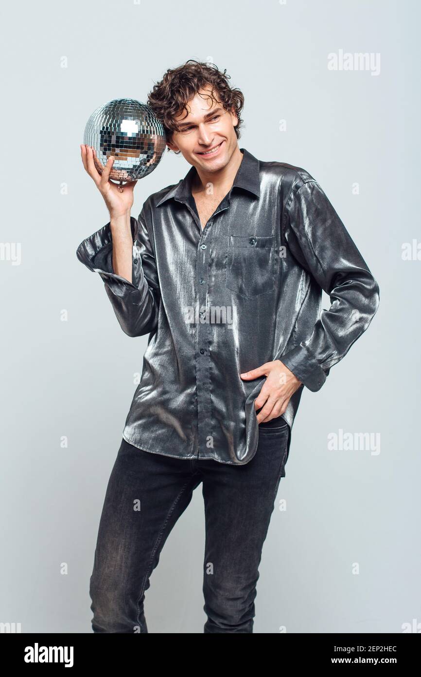 Portrait of tall attractive man with a mirror disco ball on a white ...