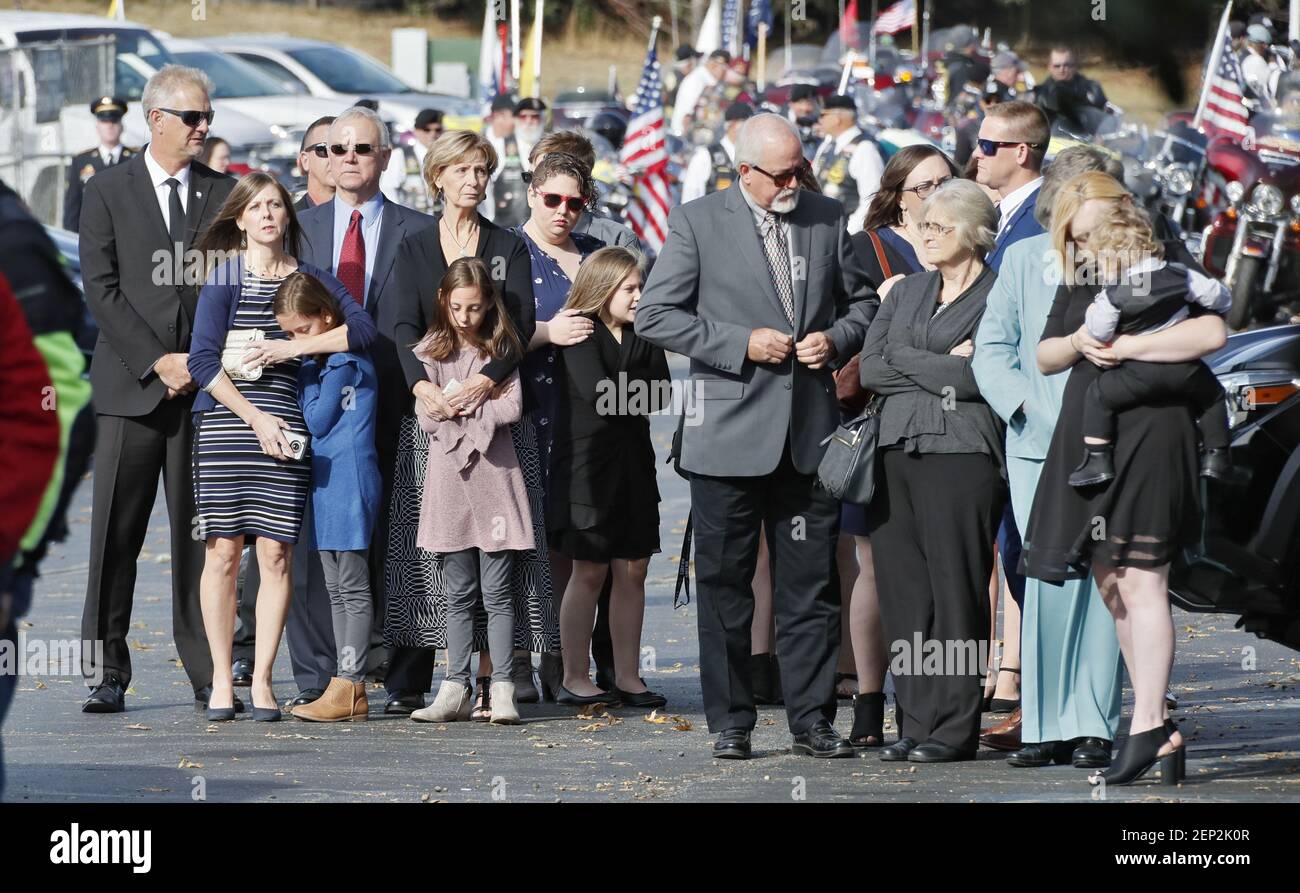 Family members stand behind the hearse after it arrived at the funeral ...