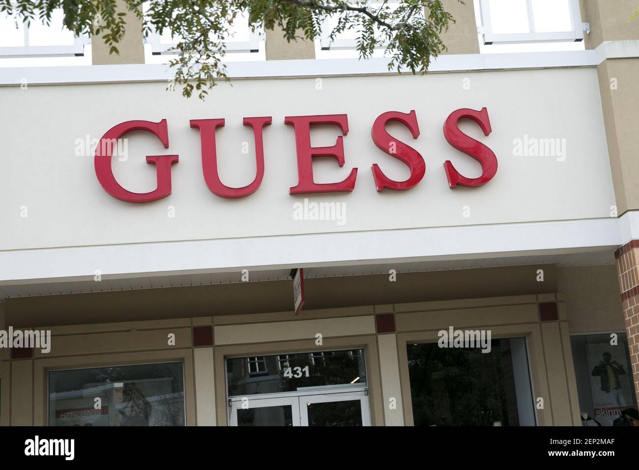 A logo sign outside of a Guess retail store location in Queenstown ...