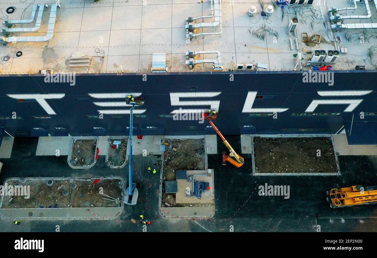 Construction workers put up the "Tesla" logo on the outside wall of ...