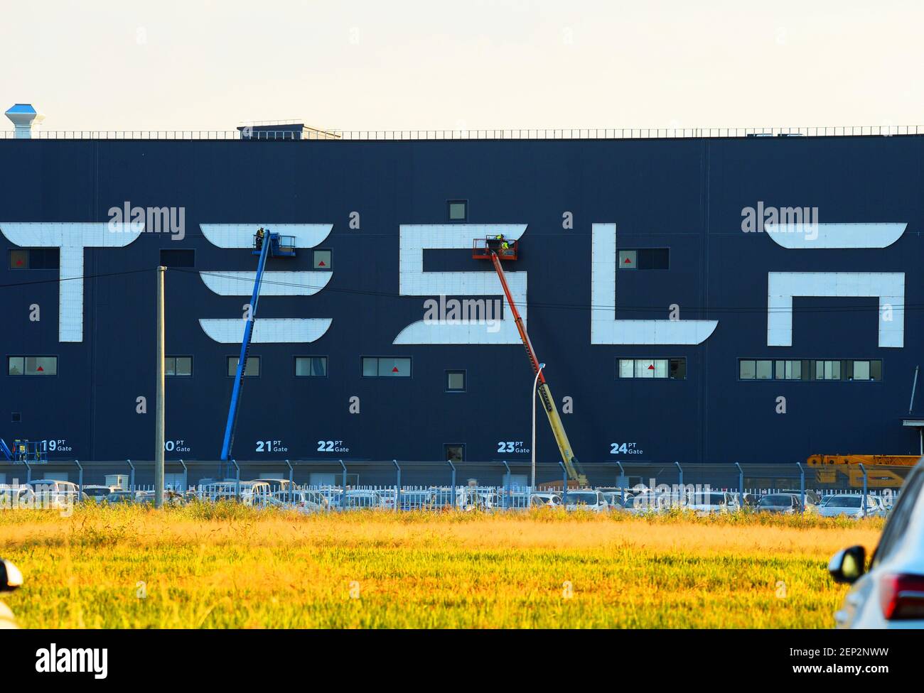 Chinese workers install the logo of TESLA on the facade of the Tesla ...