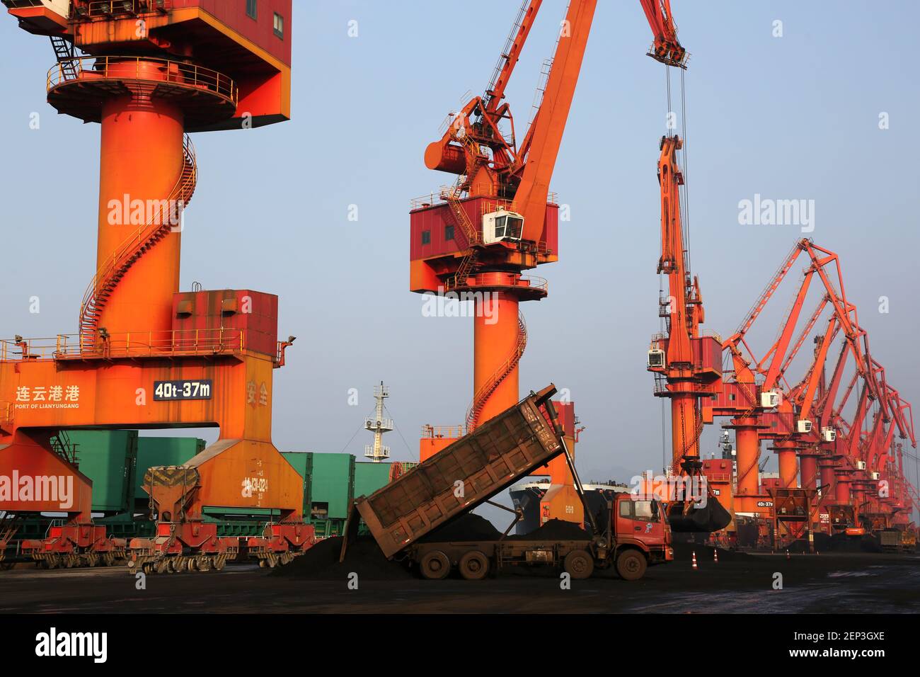 Grab bucket cranes along a quay load ships with coal to be used for ...