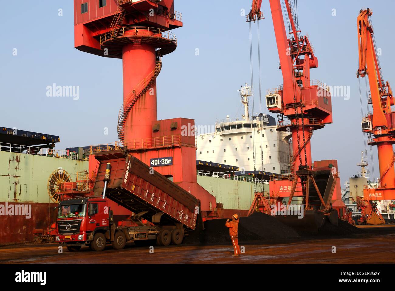 Grab bucket cranes along a quay load ships with coal to be used for ...