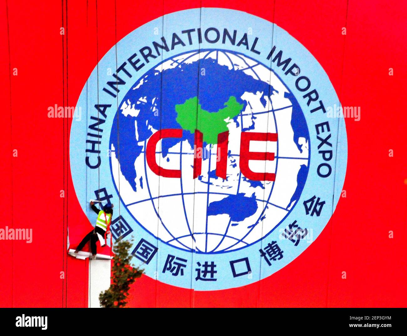 Construction workers put the logo of CIIE onto the wall of the ...