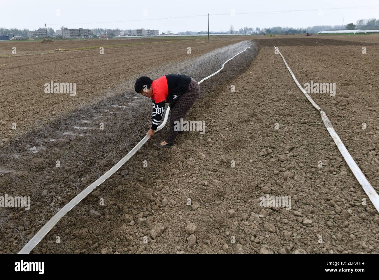 A farmer prepares to water the filed to fight against severe drought in ...