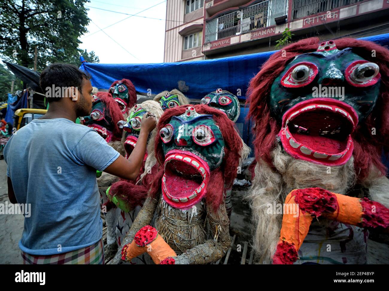 An Artist adds detail to a clay sculpture of a demon ahead of Kali Puja ...