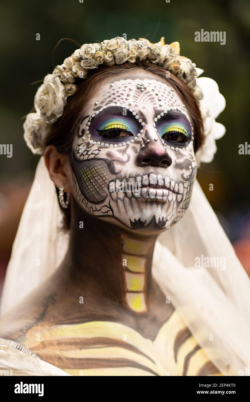 A woman with her face painted poses for a photograph during the Catrina ...