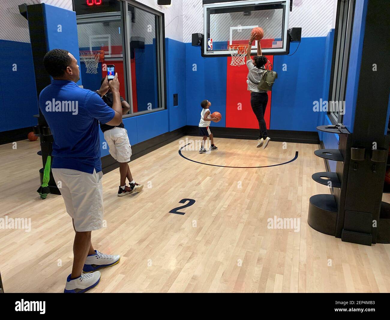 NBA Experience visitors take turns dunking on an adjustable goal and ...