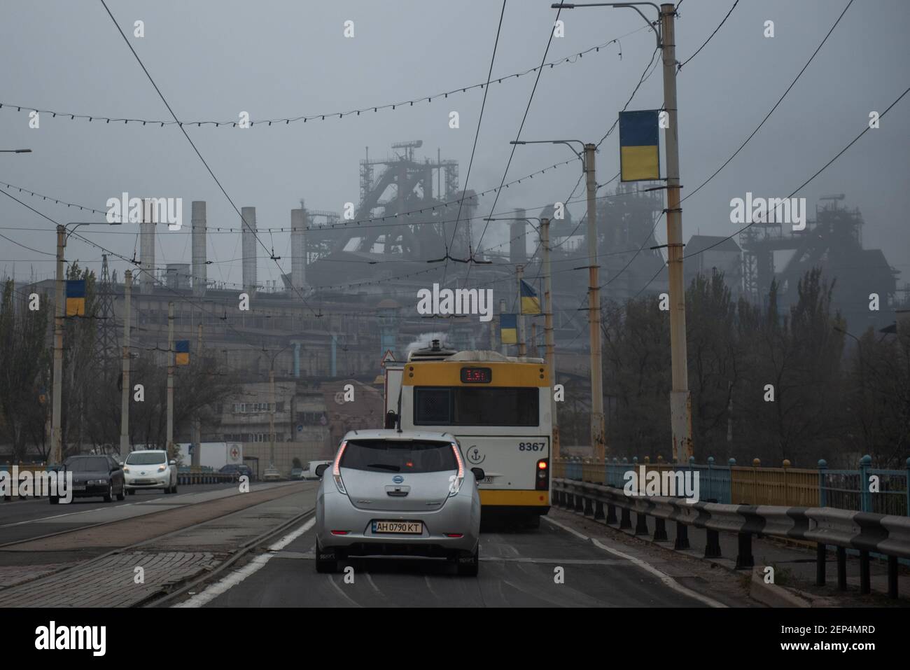 Cars drive by an Azov Stal steel plant avenue in in Mariupol. The two ...