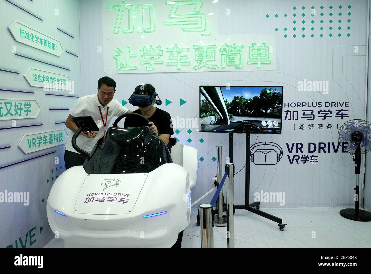 A customer experiences how to learn driving via VR technology at a ...