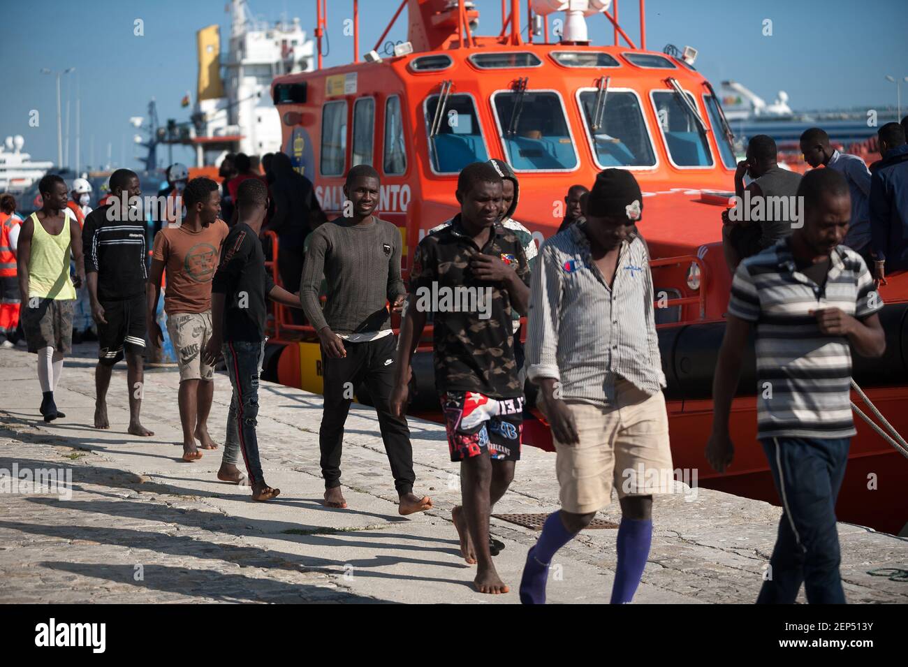 Sub Saharan migrants queue up towards a humanitarian emergency stall ...