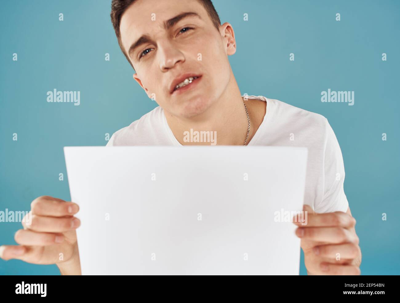 guy with flyer in hand Poster mockup blue background cropped view Stock ...