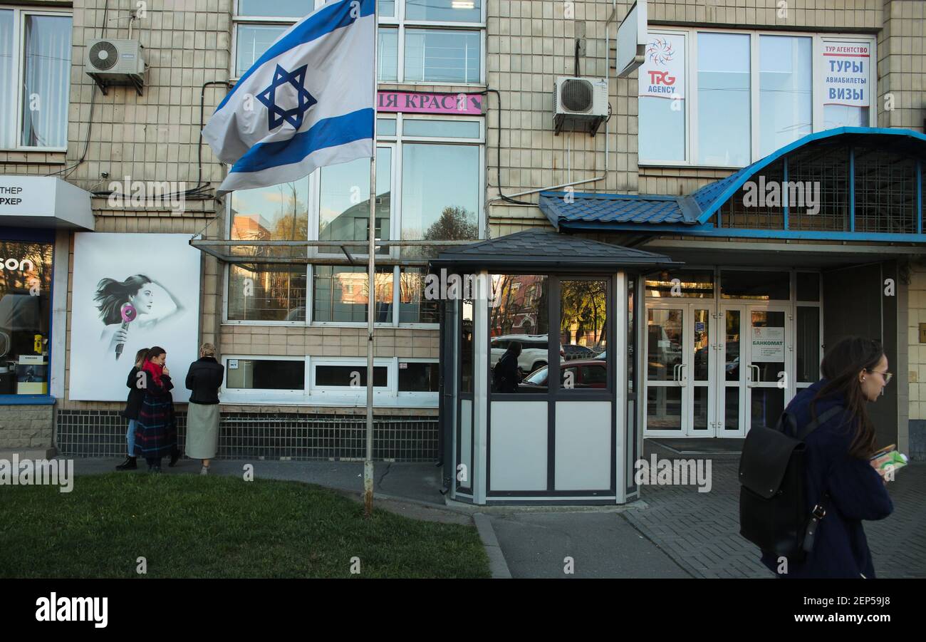 Women have a smoke next to the Israeli state flag set in front of the ...