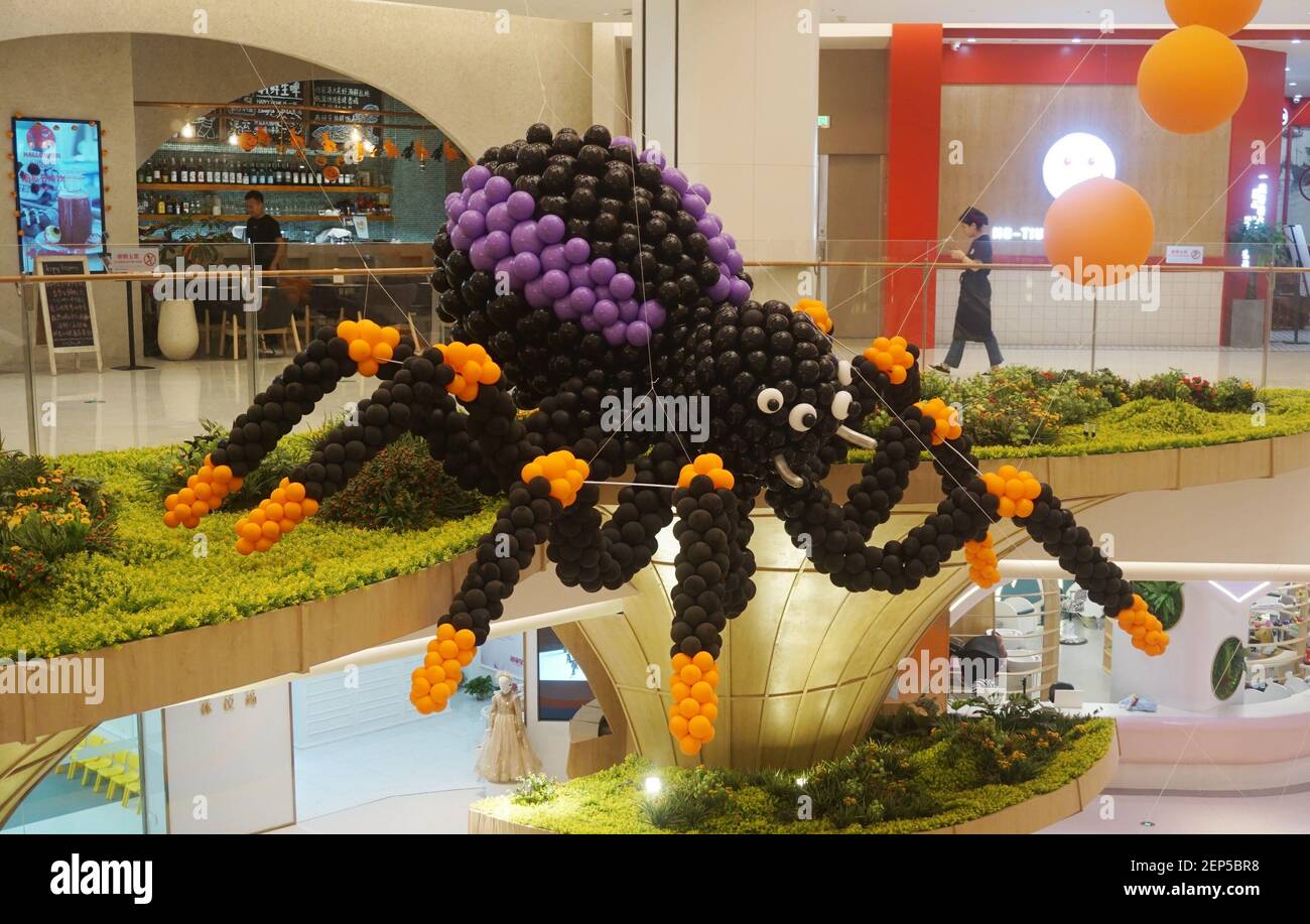 A giant spider made of balloons is put in the lobby of a shopping mall ...
