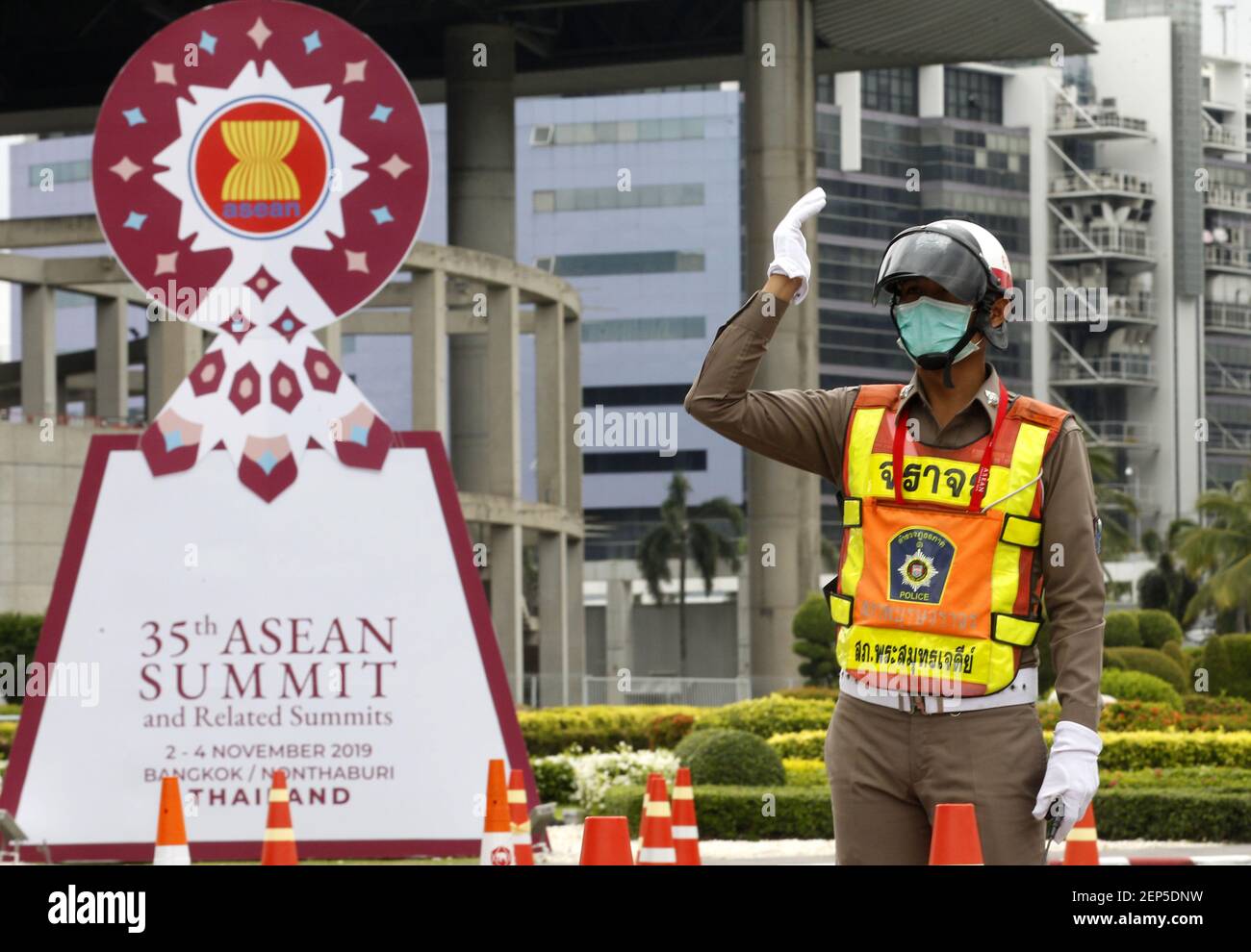 A Thai policeman stands on guard while making a gesture ahead of the ...