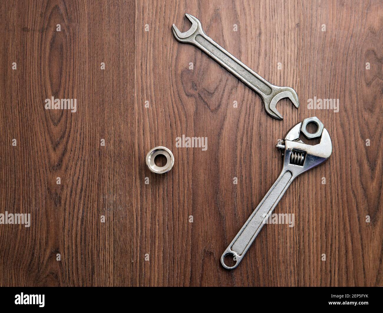 Two wrench and nuts on brown surface Stock Photo - Alamy